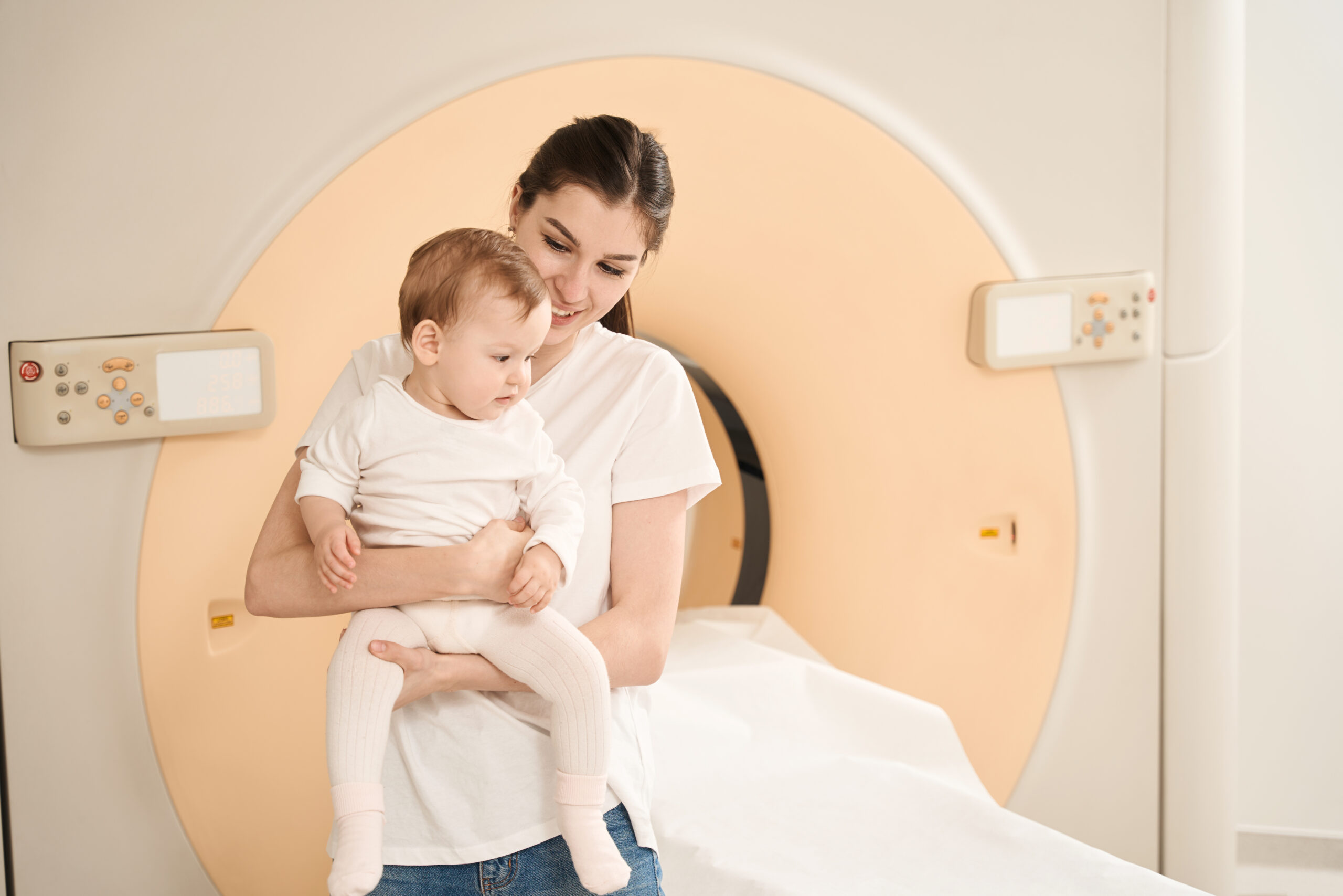 Cheerful female with her baby before magnetic resonance imaging ...
